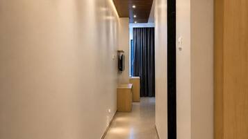 Um corredor moderno com teto de madeira, iluminação embutida e piso nivelado.