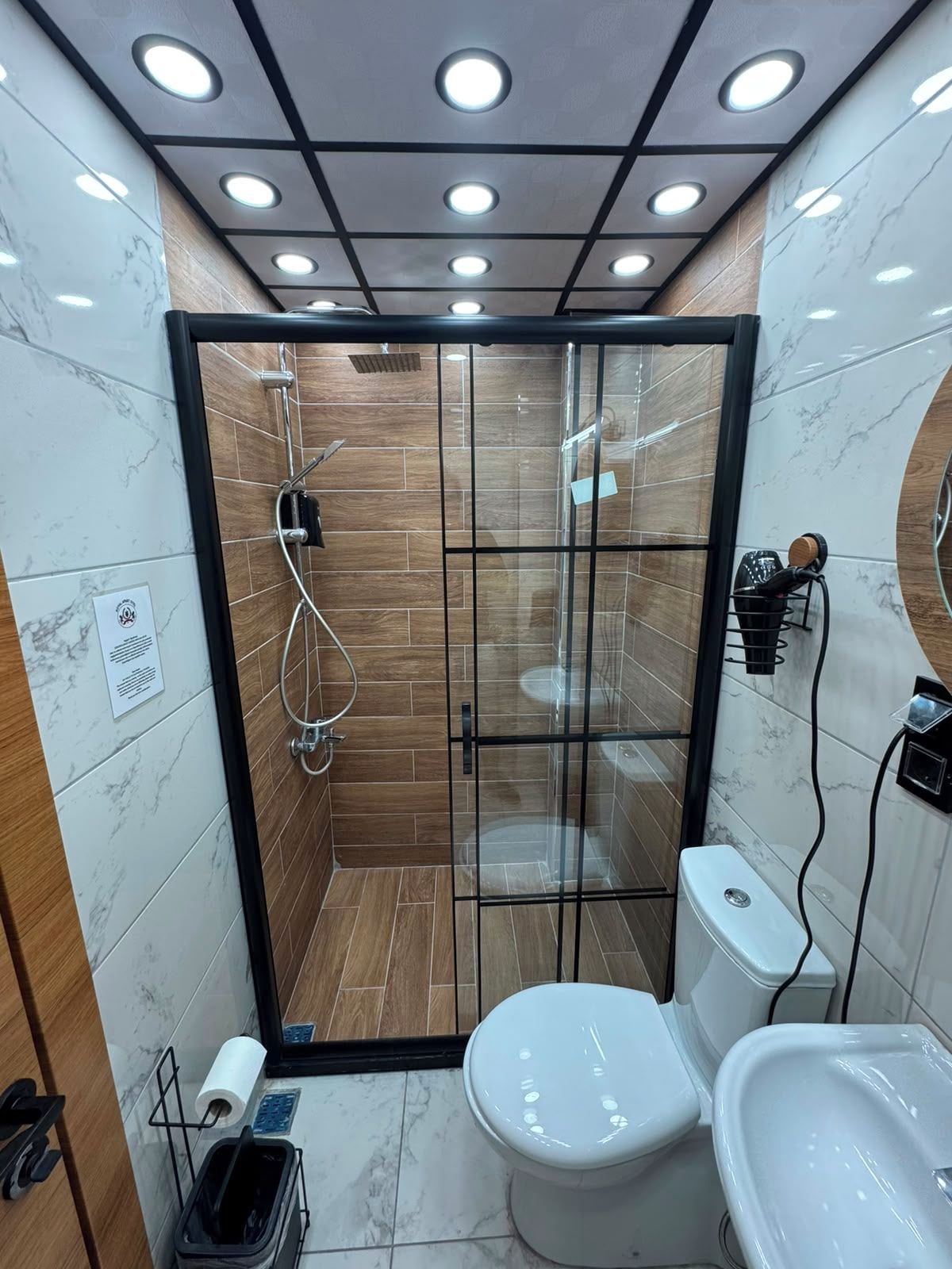 Uma casa de banho moderna com cabine de duche em vidro, sanita e bidé.