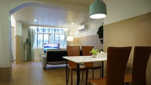 Uma sala de jantar moderna com uma mesa e cadeiras, uma televisão e uma janela com vista para uma ponte.