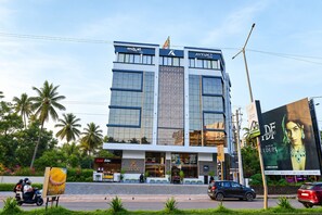 Um hotel com várias andares, fachada moderna, grandes janelas e entrada imponente.