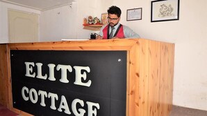 Uma mesa de recepção com uma placa que diz 'ELITE COTTAGE'.