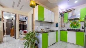 Uma cozinha com armários verdes e brancos, um fogão e uma pia.