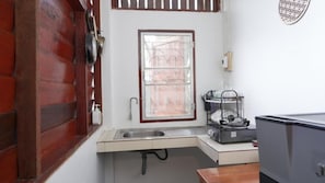 Uma cozinha compacta com pia, janela e bancada pequena.