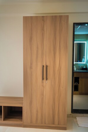 Um guarda-roupa com duas portas e um banco em frente.