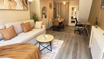 Sala de estar com sofá, mesa de centro e área de jantar com cadeiras e mesa.