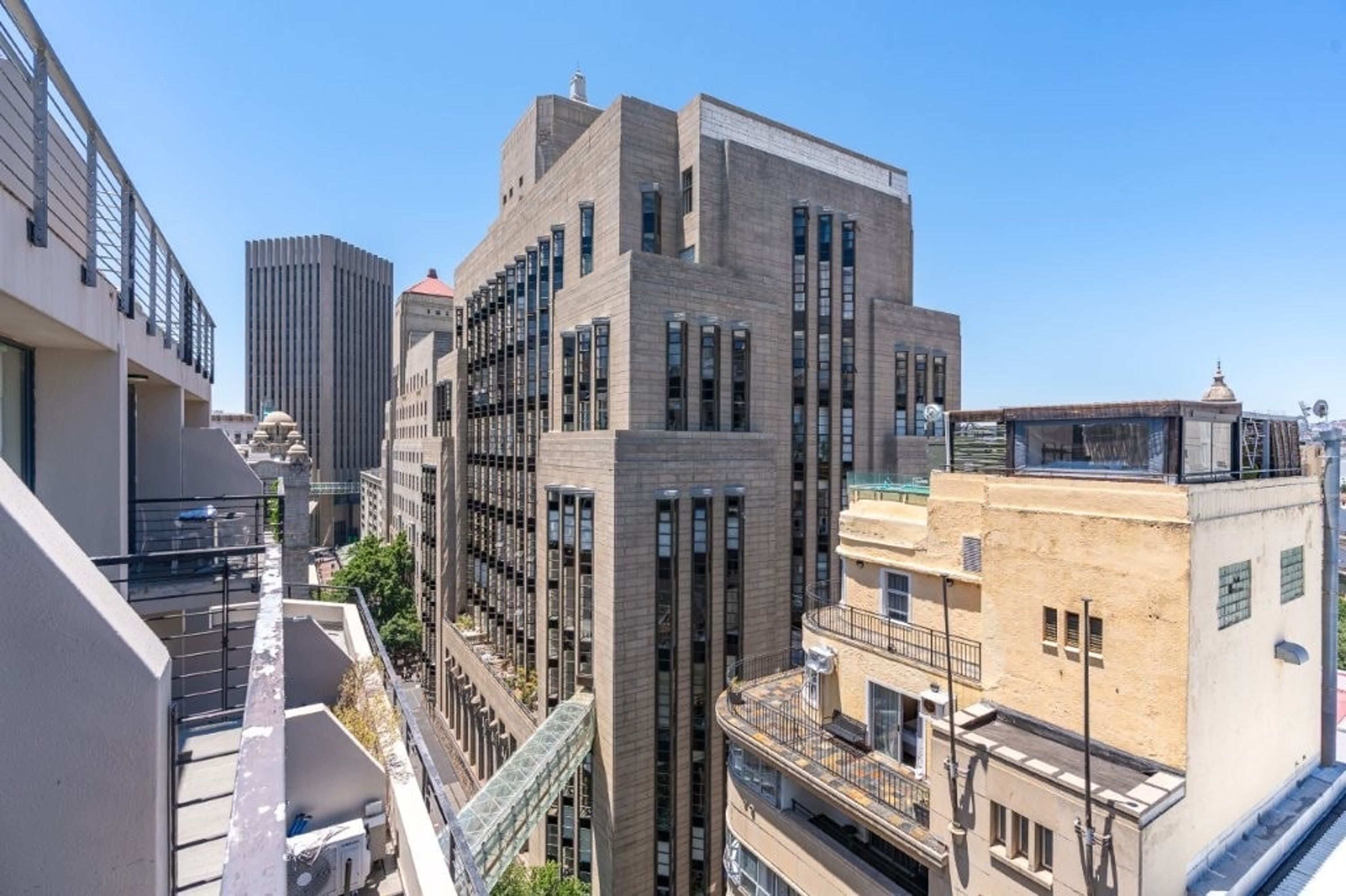 Um edifício de vários andares com arquitetura moderna, combinando fachadas de vidro e tijolo.