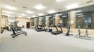 Uma academia com esteiras, bicicletas ergométricas e aparelhos de musculação.
