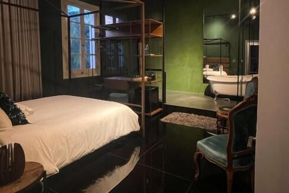 Quarto moderno com uma cama grande, uma escrivaninha e uma cadeira.