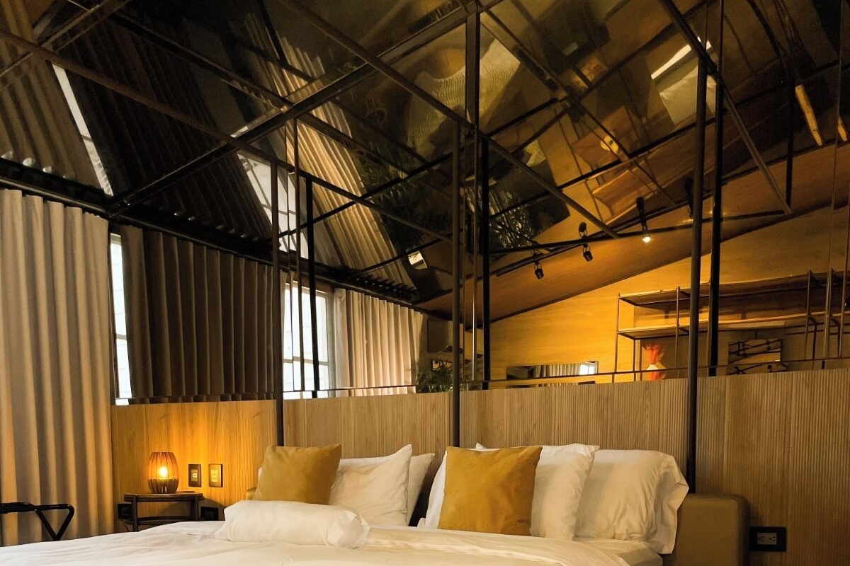 Um quarto espaçoso com uma cama grande, uma mesinha de cabeceira e uma cadeira.