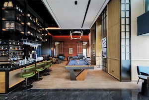 Espaço de bar com mesa de bilhar e assentos.