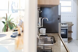 Uma cozinha moderna com forno embutido, pia e bancada.