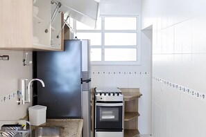 Uma cozinha com forno embutido, pia e janela.
