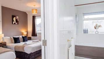 Quarto de hotel com cama, mesa de cabeceira, abajur e vista para o exterior.