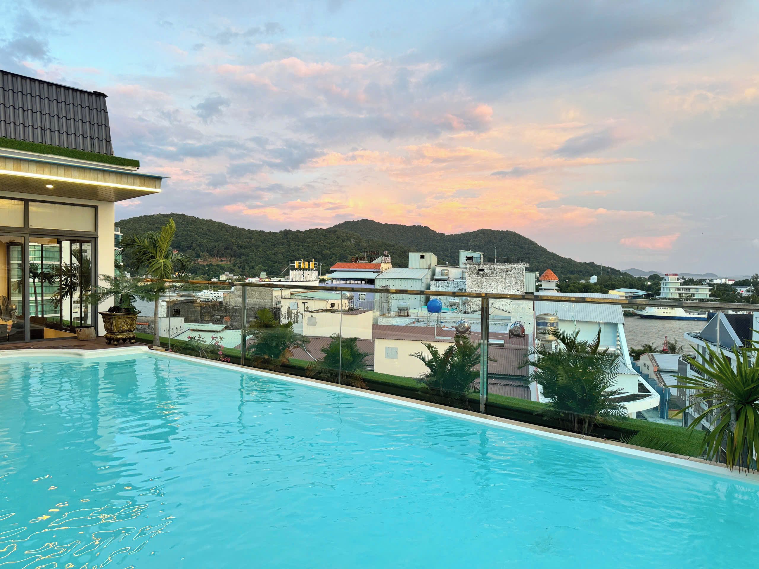 Piscina com vista para um horizonte urbano e montanhas ao fundo.