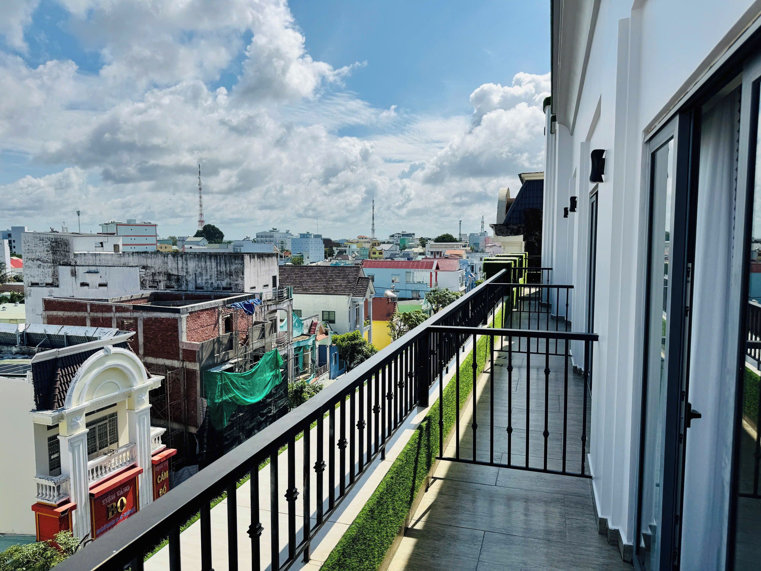 Uma varanda com vista para um horizonte urbano, incluindo edifícios e um céu claro.