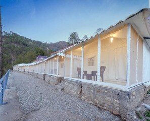 Fileira de quartos com janelas individuais e um alicerce de parede de pedra.