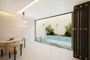 Um interior moderno com área de jantar, um espaço ao ar livre com piscina e porta deslizante.