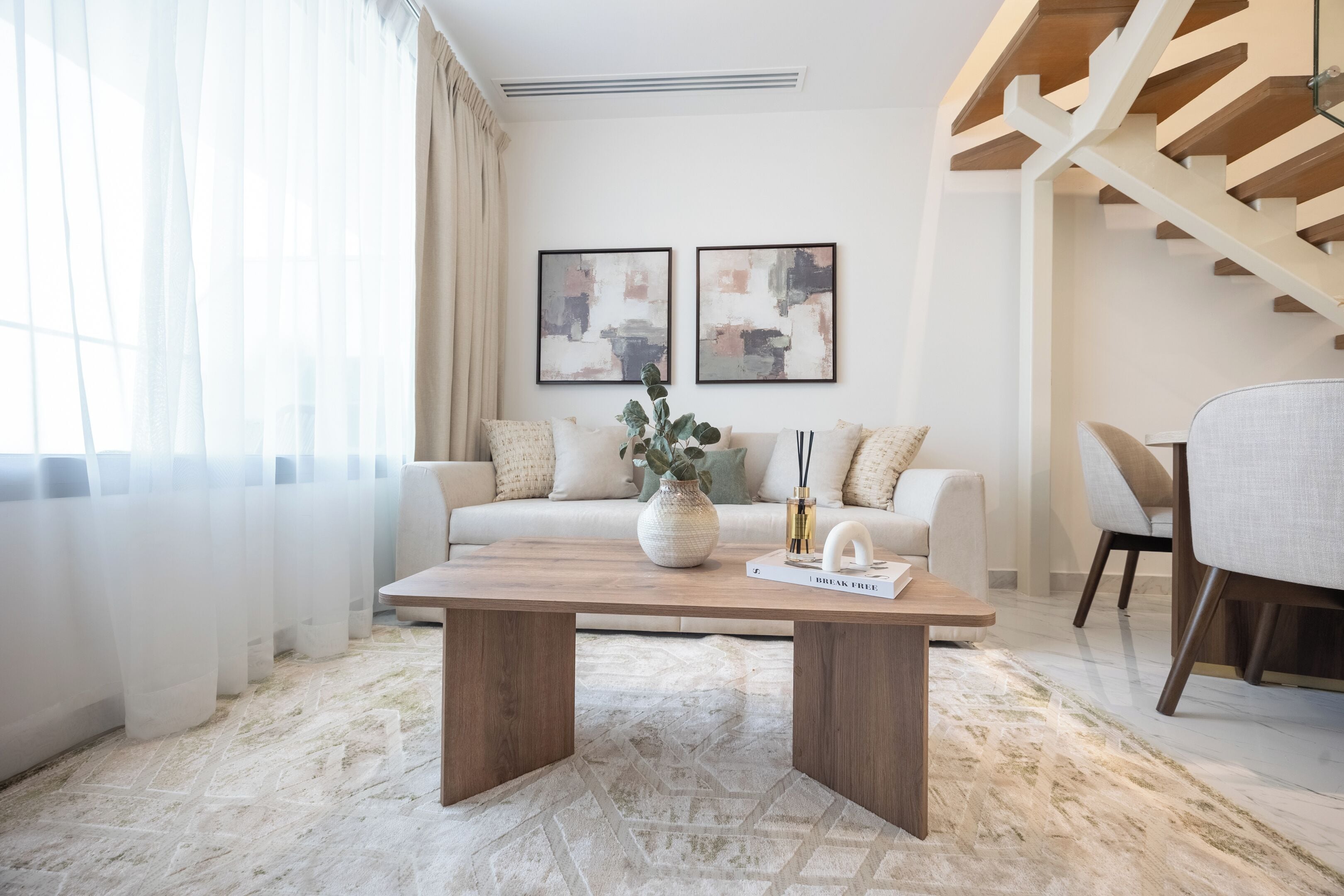 Uma sala de estar moderna com sofá, mesa de centro e obras de arte na parede.