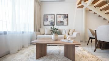 Uma sala de estar moderna com sofá, mesa de centro e obras de arte na parede.