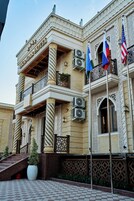 Um hotel com estilo arquitetônico tradicional, com varandas elaboradas e colunas decorativas.