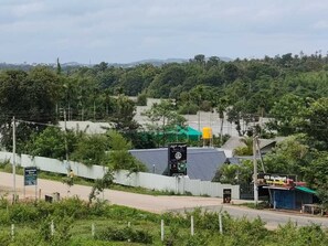 Uma área rural com estrada, cercas e um edifício com painéis solares.