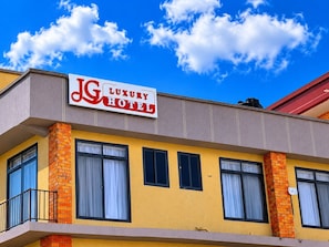Um edifício com uma placa que diz 'JG Luxury Hotel' na fachada.