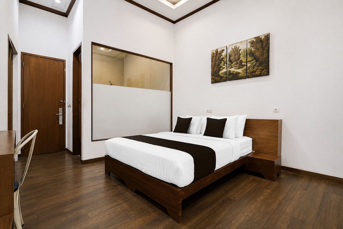 Quarto com cama de madeira, um espelho grande e um quadro na parede.