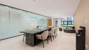 Um interior moderno com uma mesa de mármore, cadeiras, um sofá e uma máquina de vendas.