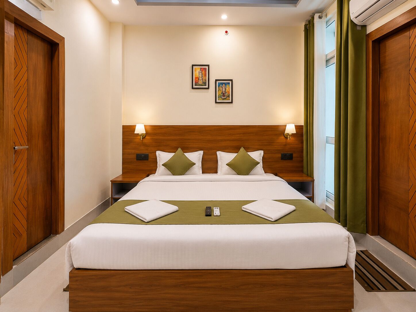 Quarto de hotel com uma cama grande, duas luminárias laterais, uma cabeceira e uma obra de arte na parede.