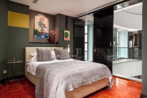 Um quarto moderno com uma cama grande, um quadro e um vaso com flores.
