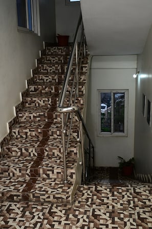 Uma escadaria com azulejos estampados e corrimãos de metal.