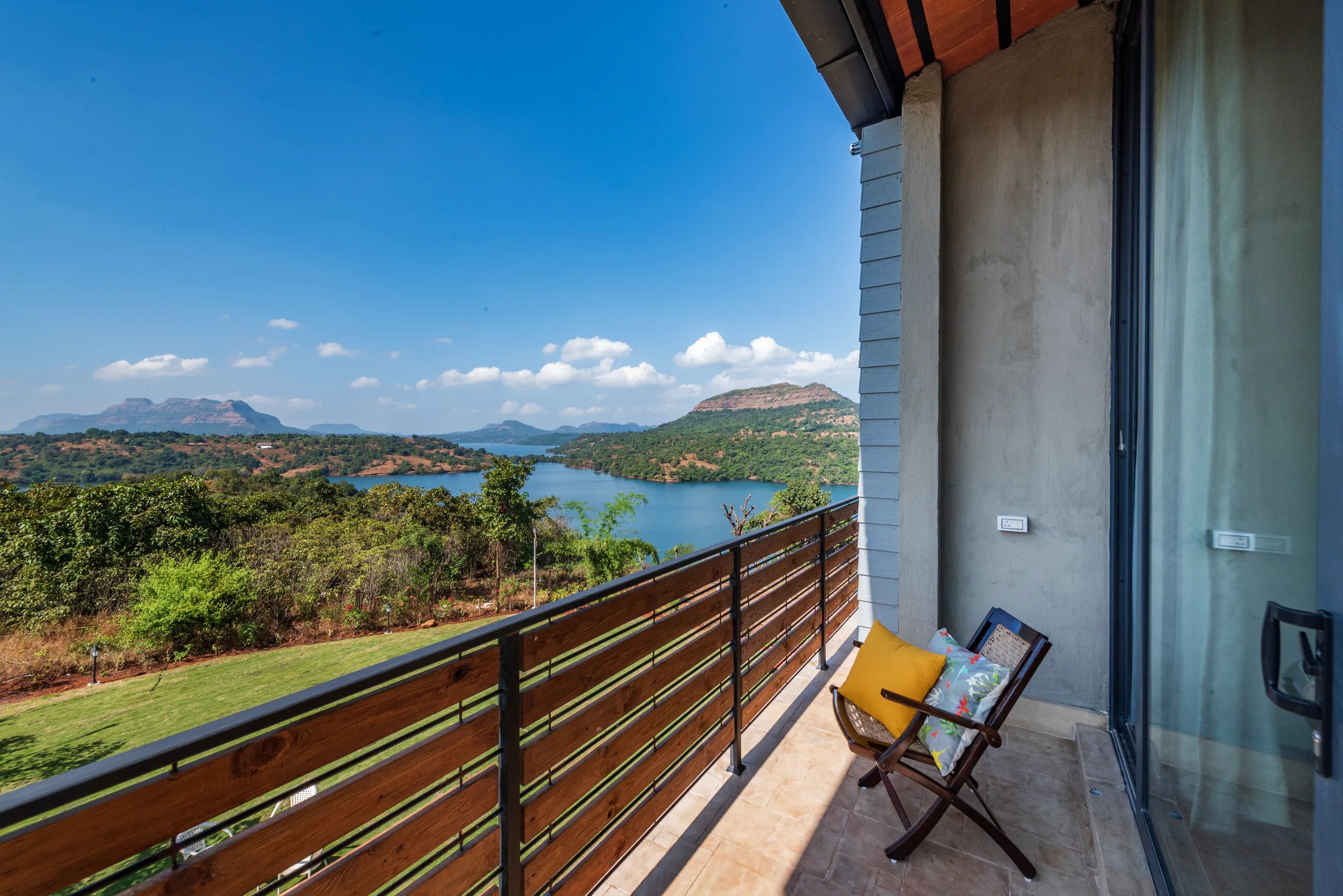 Varanda com vista para um lago e montanhas.