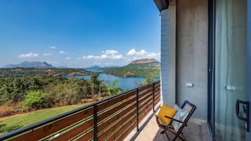 Varanda com vista para um lago e montanhas.