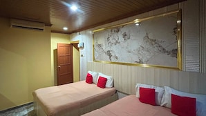 Quarto de hotel com duas camas, teto de madeira, chão de mármore e um quadro grande na parede.