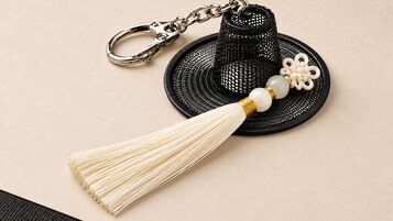 Um chaveiro com um pendente, um item tecido preto e um objeto branco com contas.
