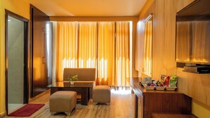 Uma sala de estar moderna com sofá, um banquinho e uma pequena mesa com uma planta.