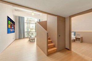 Um interior moderno com escada, área de refeições e vista através de grandes janelas.