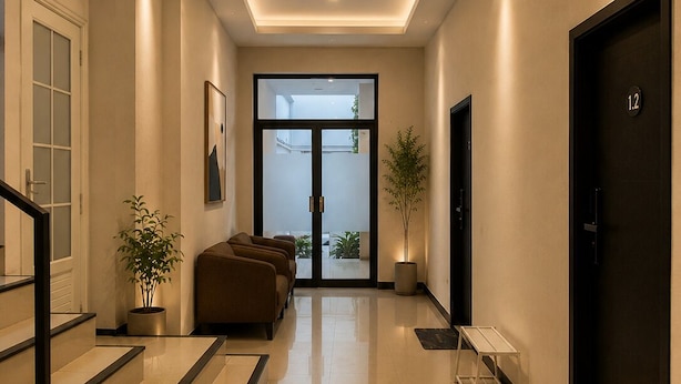 Um lobby moderno de hotel com escadaria, área de estar e balcão de recepção.