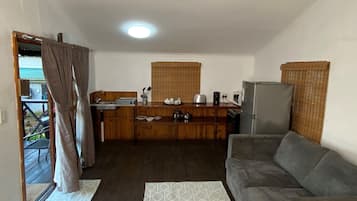 Um espaço compacto com cozinha compacta, sofá e área de refeições.