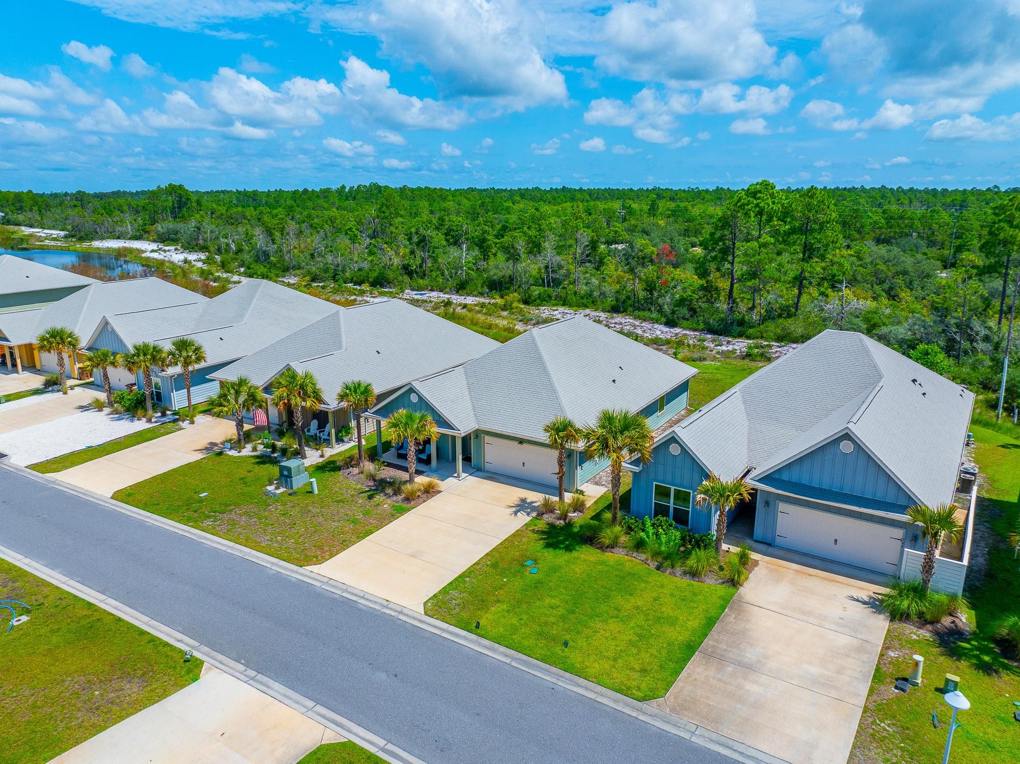 Área residencial com várias casas, telhados inclinados e jardins frontais.