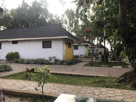 Um edifício com telhado de cerâmica, uma pequena varanda e aparelhos de ar condicionado.