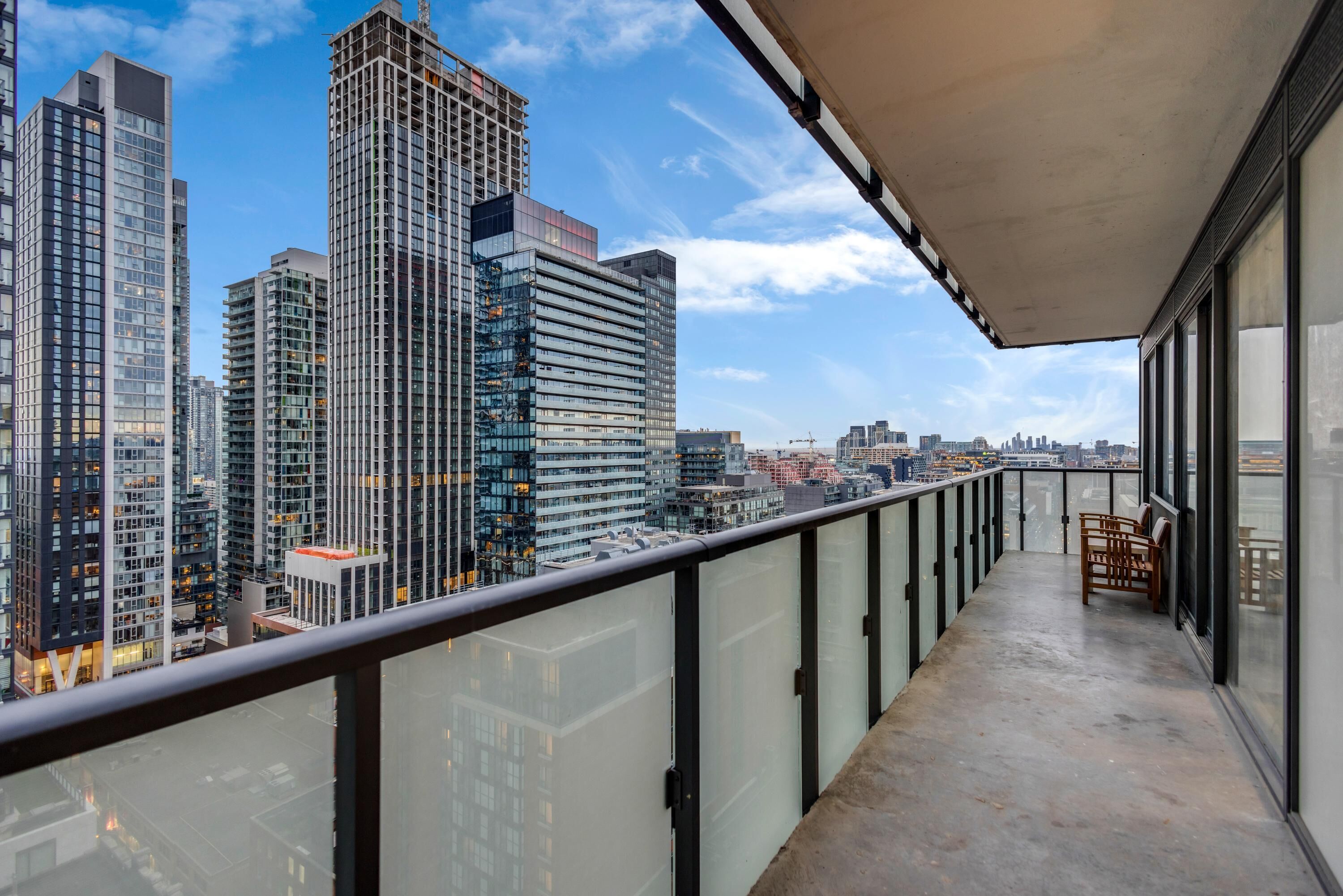 Uma varanda com vista para edifícios altos e o horizonte da cidade.