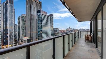 Uma varanda com vista para edifícios altos e o horizonte da cidade.