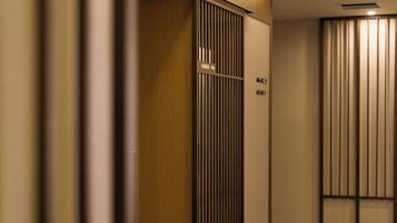 Corredor com porta de madeira identificada como 'LOUNGE' e uma grade de metal vertical.