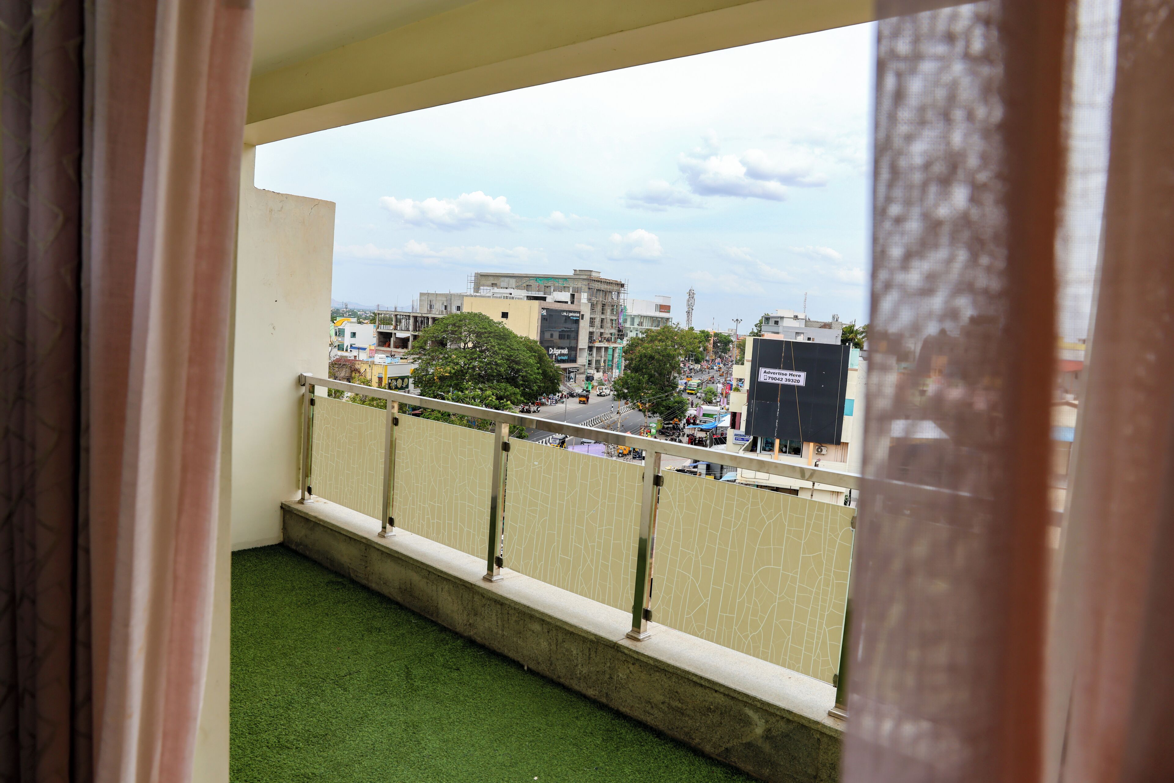 Uma varanda com vista para a paisagem urbana, incluindo edifícios e céu claro.