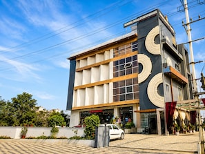 Um edifício moderno com uma placa de destaque que diz 'SHUBH SHALEEN SPRINGS'.