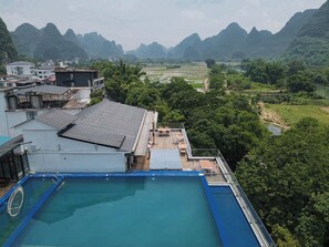 Piscina no terraço com vista para uma paisagem montanhosa.