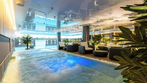 Uma área interna de piscina moderna, com assentos e plantas.