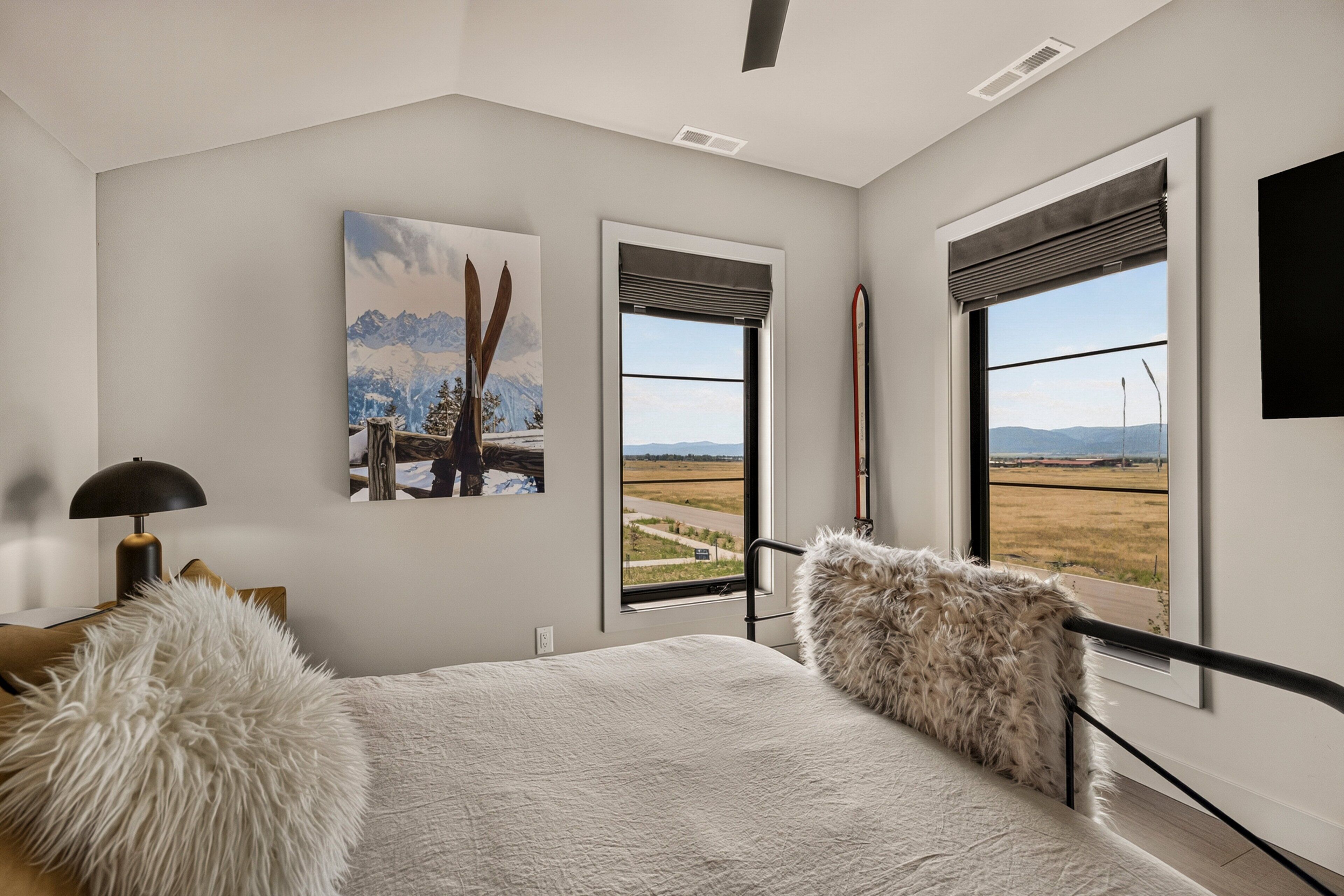 Quarto com cama grande, um quadro e um bastão de esqui.
