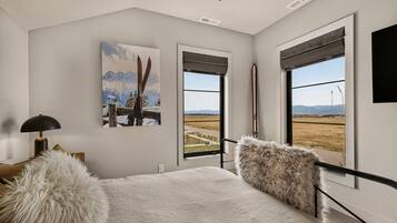 Quarto com cama grande, um quadro e um bastão de esqui.